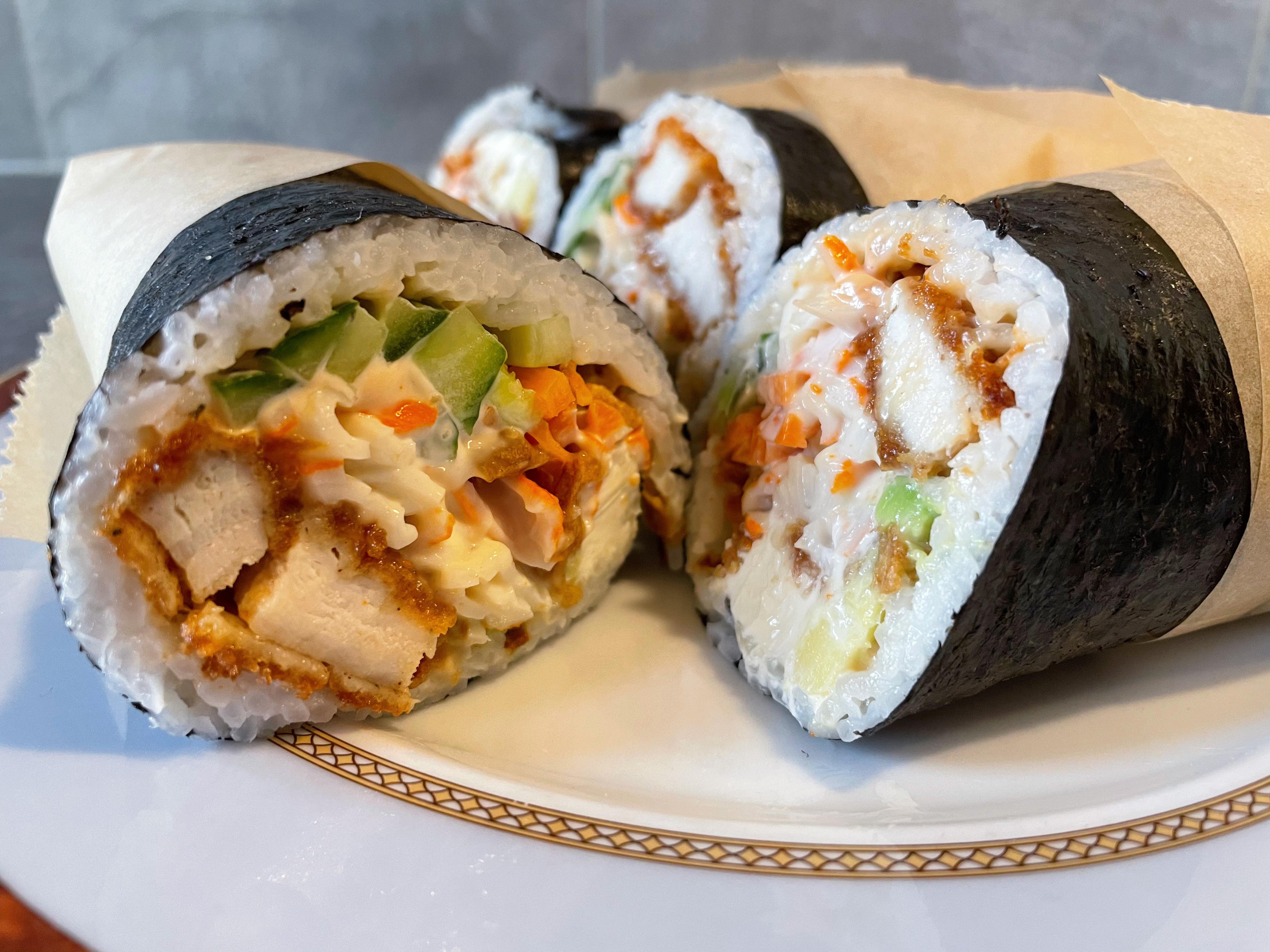 Sushi burrito consisting of panko chicken, imitation crab, cucumber ...
